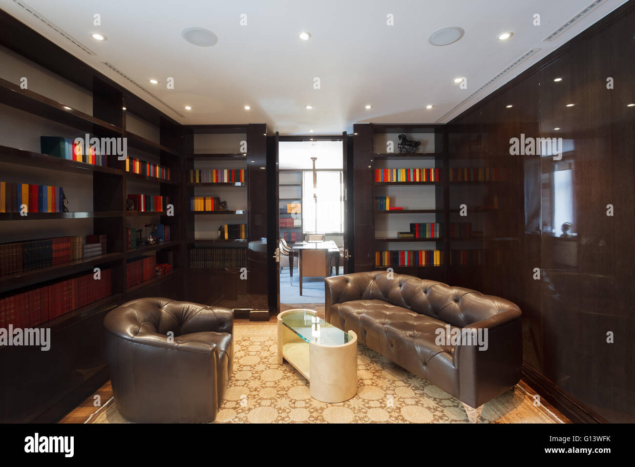 Luxury office interior. Library, leather sofa, designer table and works ...