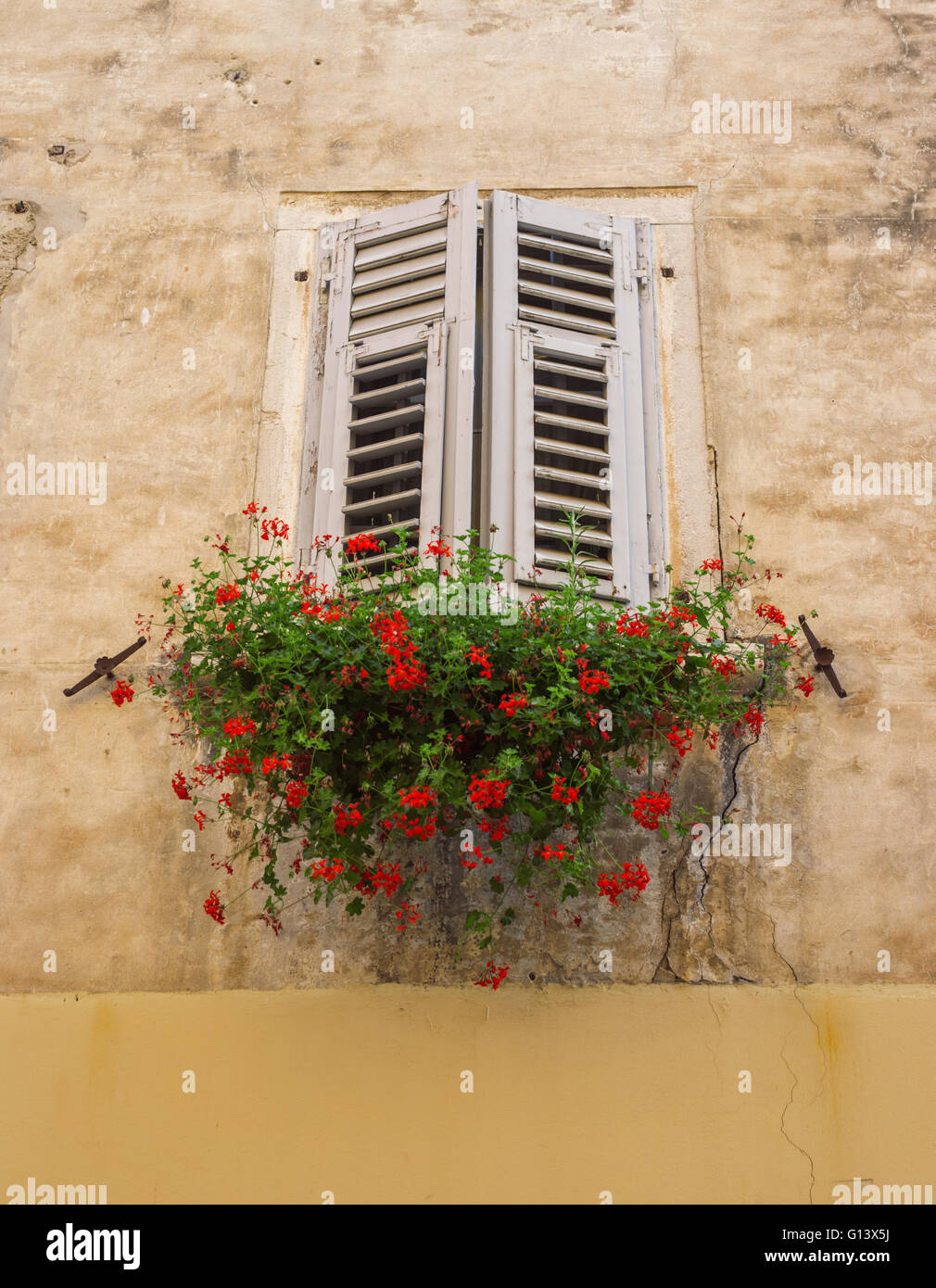 Old window decorated with red flowers Stock Photo - Alamy