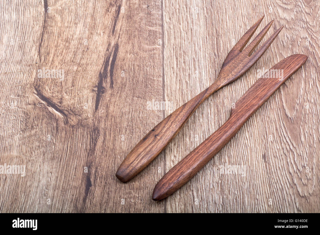 Wooden cutlery on a brown wooden background background Stock Photo - Alamy