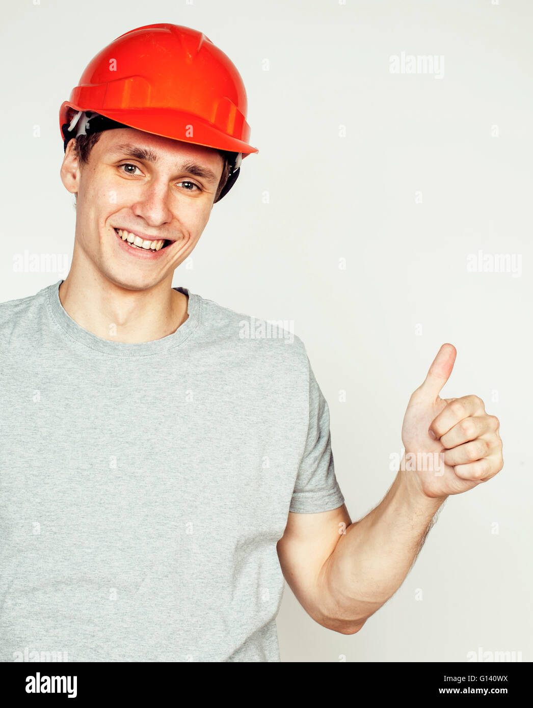 young real hard worker man isolated on white background on ladder ...