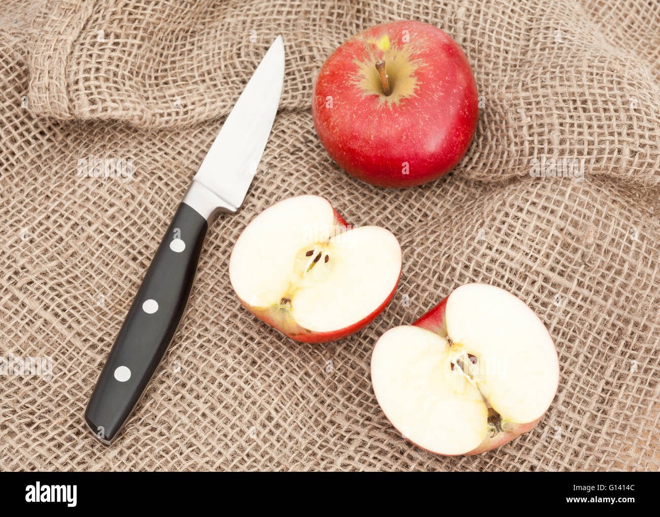 Sliced and whole apple on burlap with knife Stock Photo - Alamy