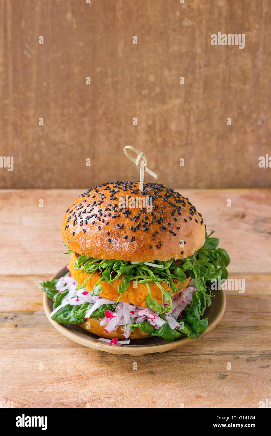 Homemade veggie sweet potato burger with fresh radish and pea sprouts ...