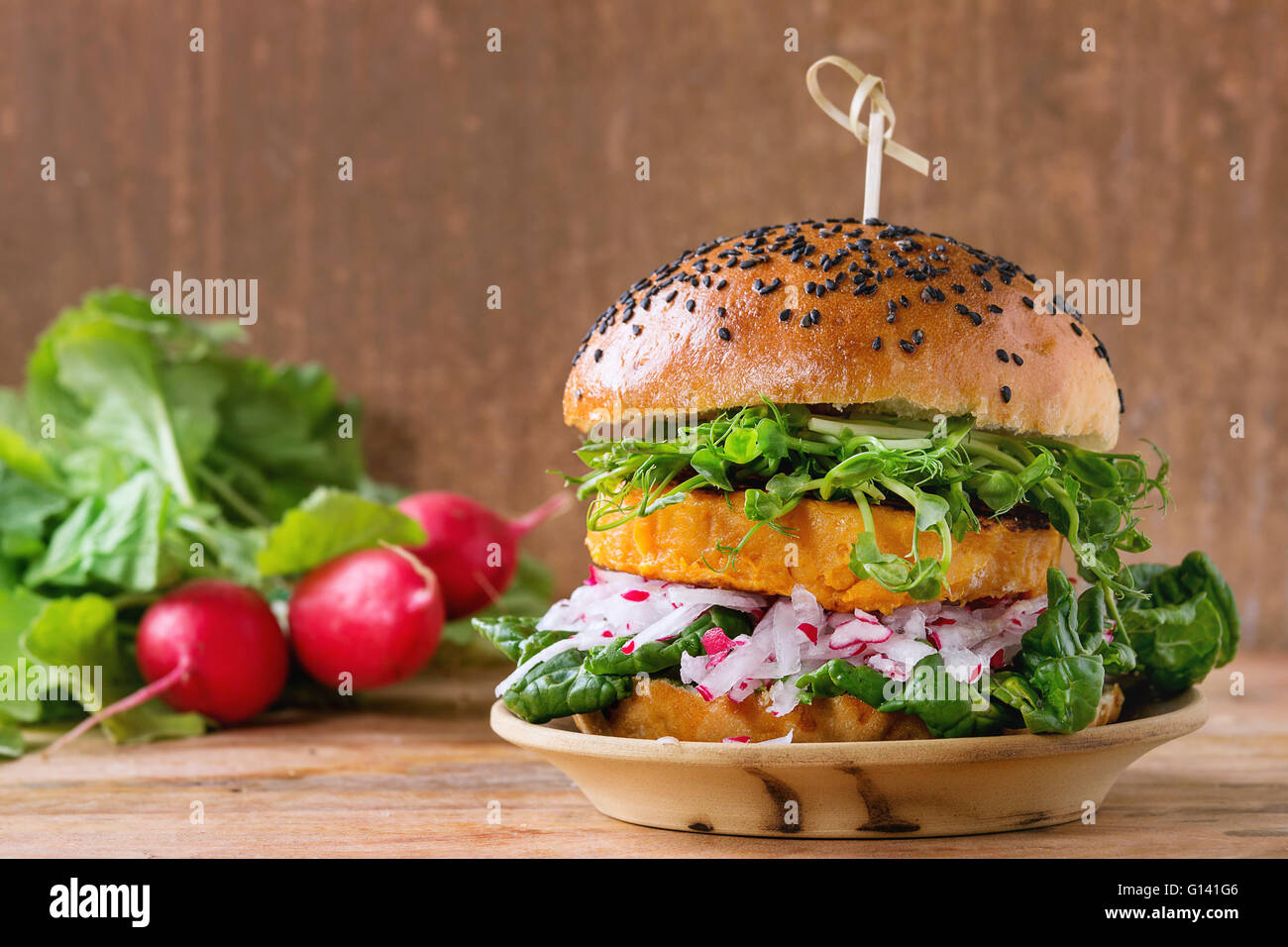 Homemade veggie sweet potato burger with fresh radish and pea sprouts ...