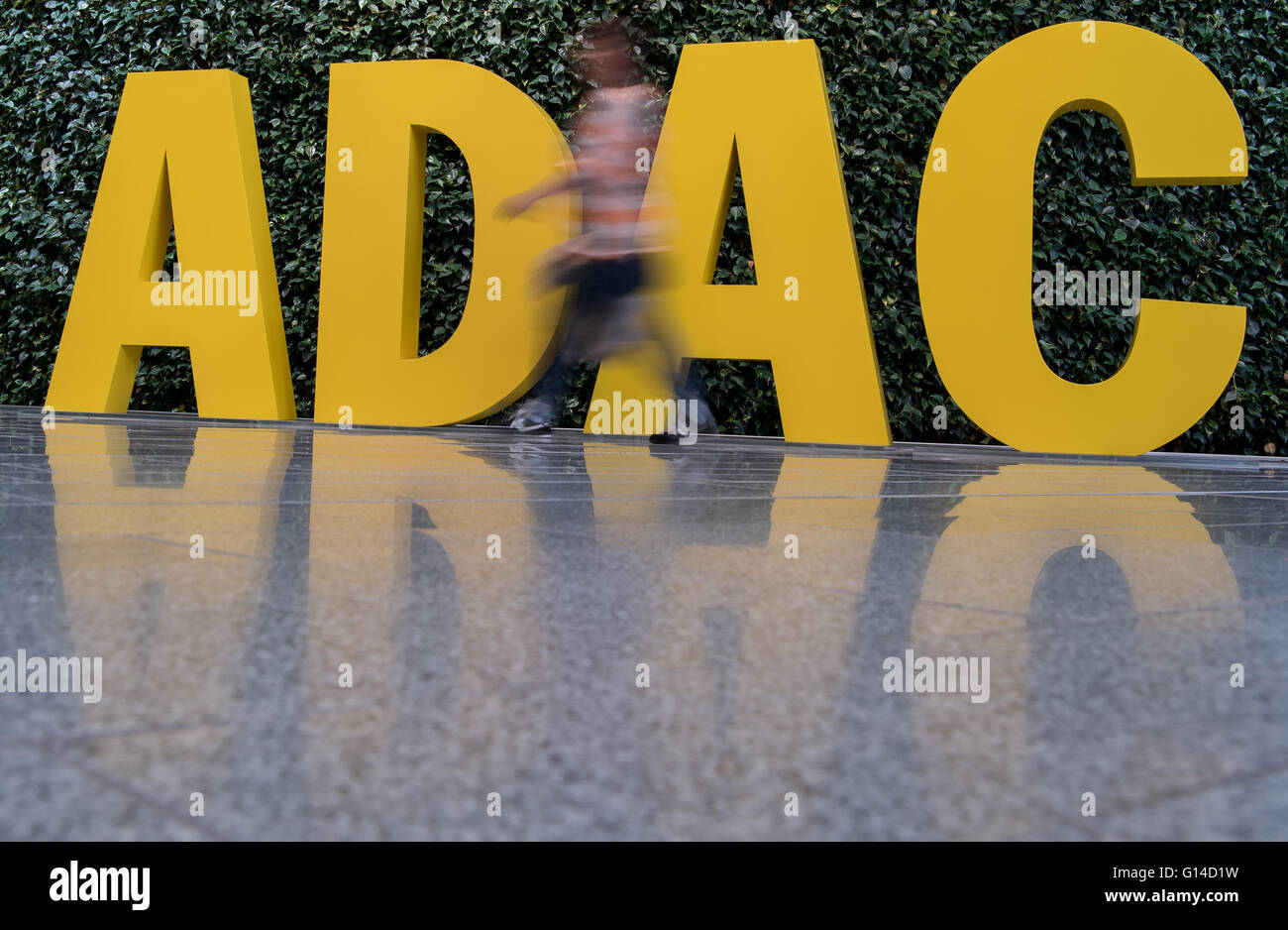 Munich, Germany. 09th May, 2016. A woman walks past the ADAC logo ahead ...