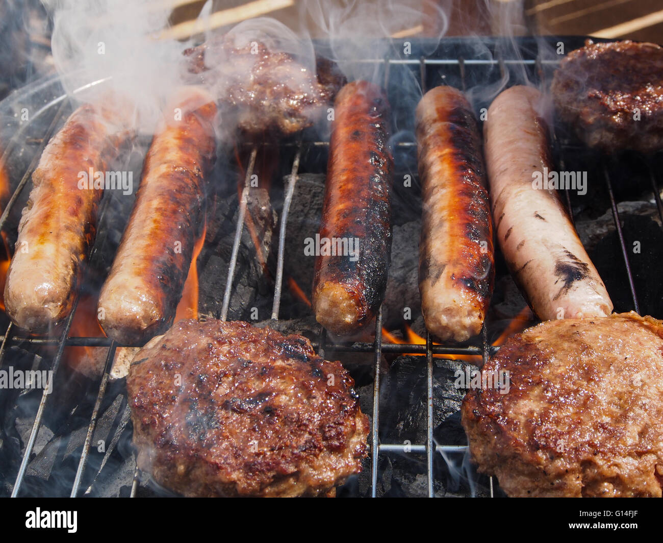 sausages and burgers being cooked on a barbecue Stock Photo - Alamy