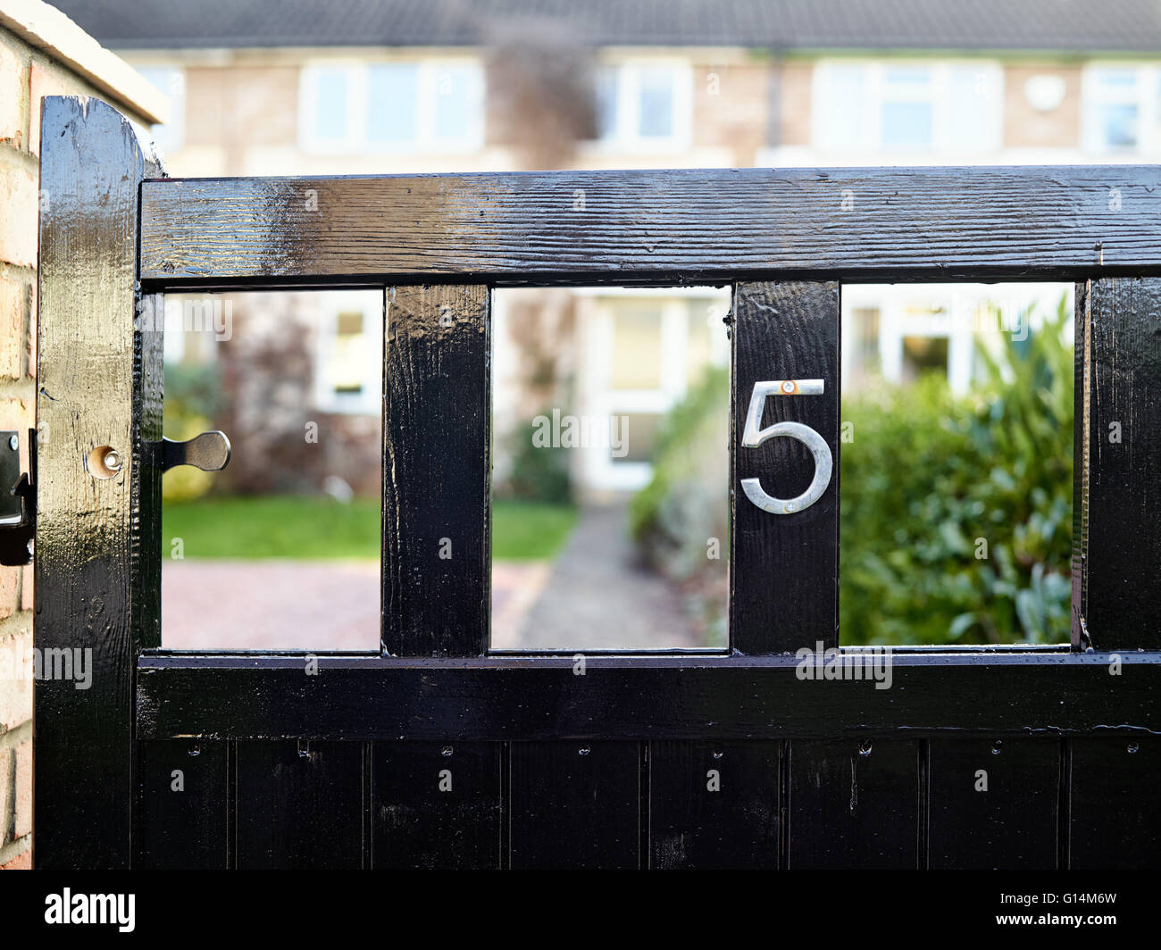 The number 5 on a black gate at the entrance to the garden path leading ...