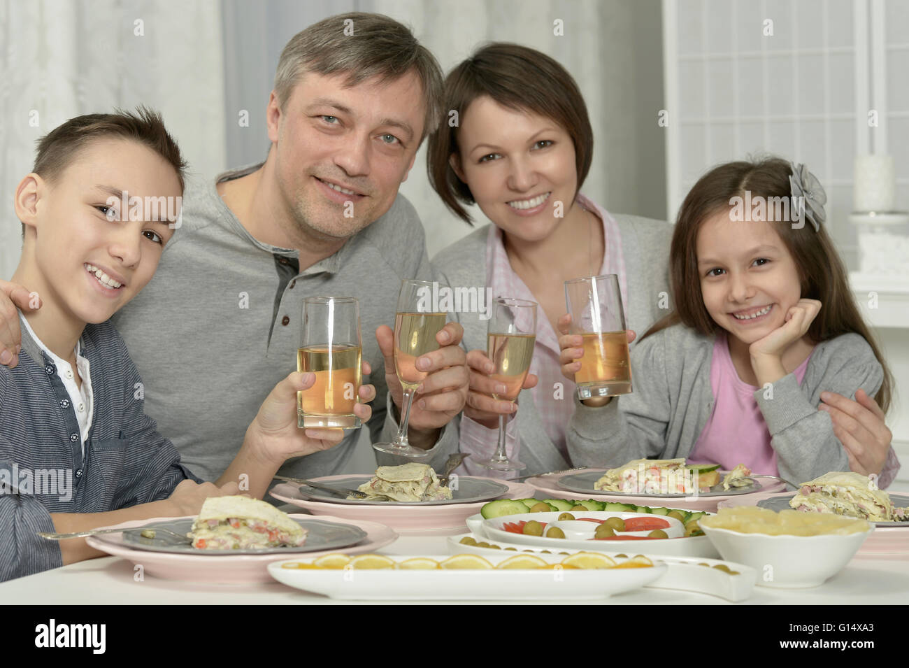 Happy family having dinner Stock Photo - Alamy