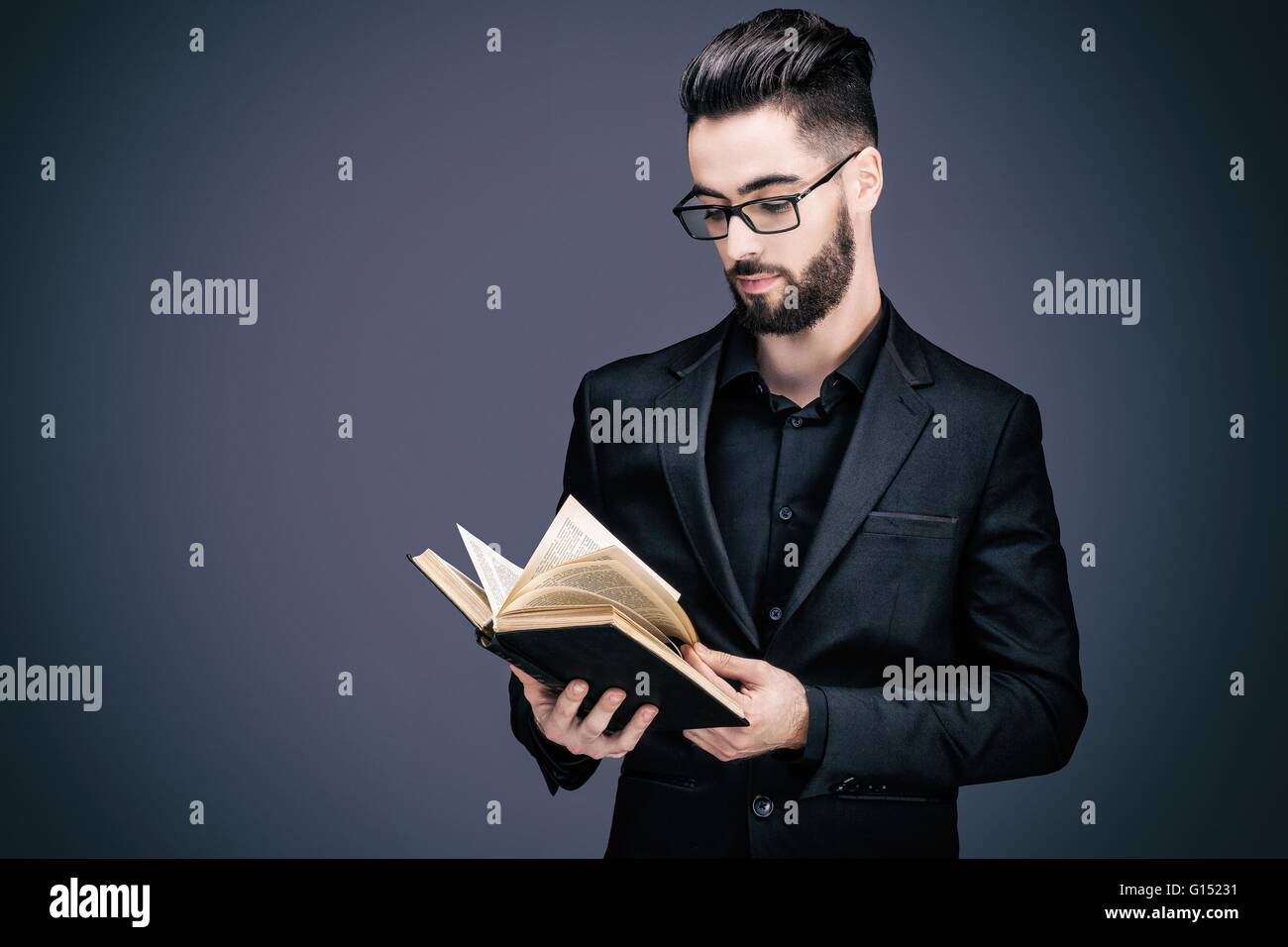 Portrait of a young man in a suit reading a book Stock Photo - Alamy