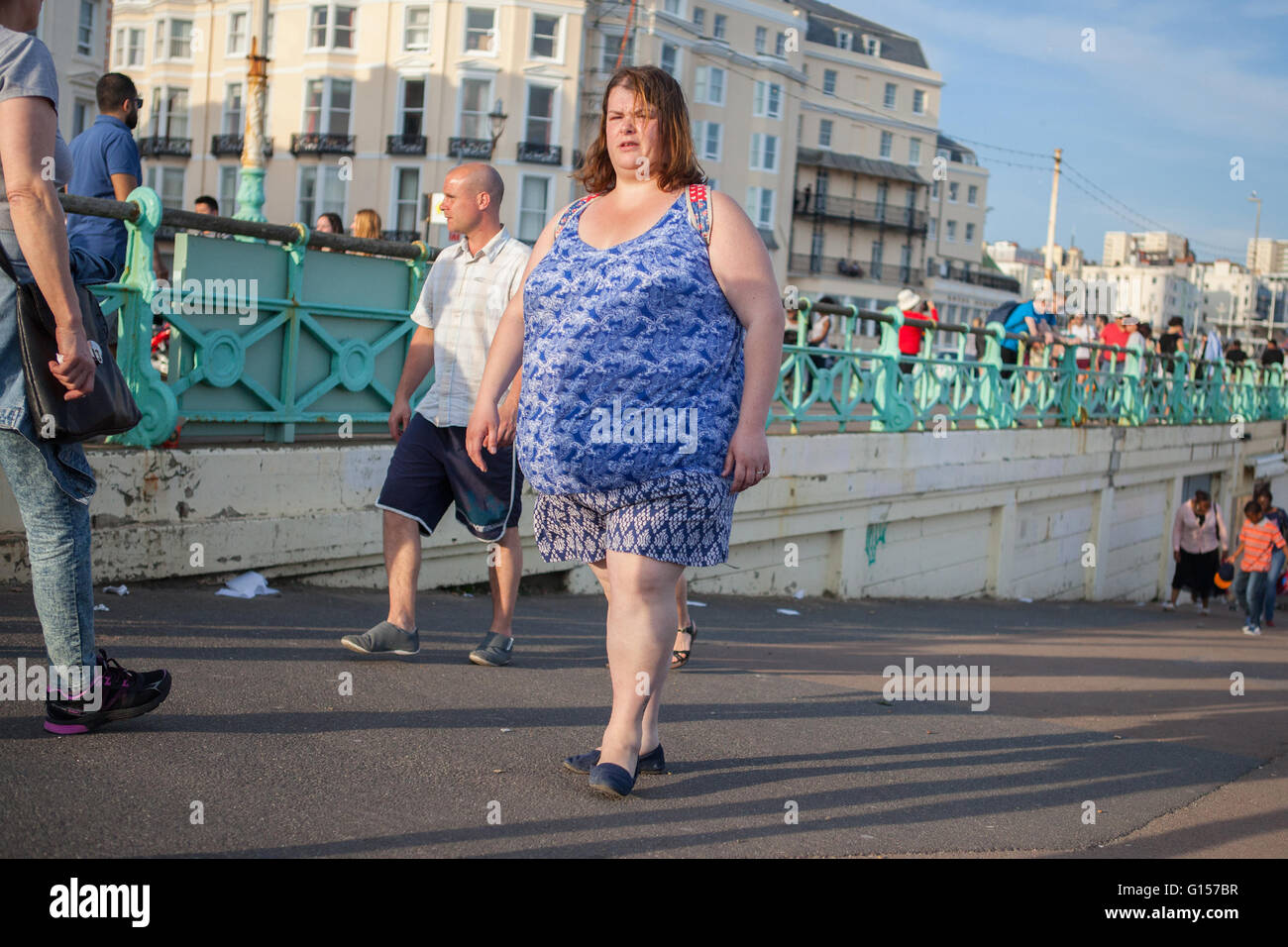 Overweight woman walking on Brighton promenade Stock Photo - Alamy