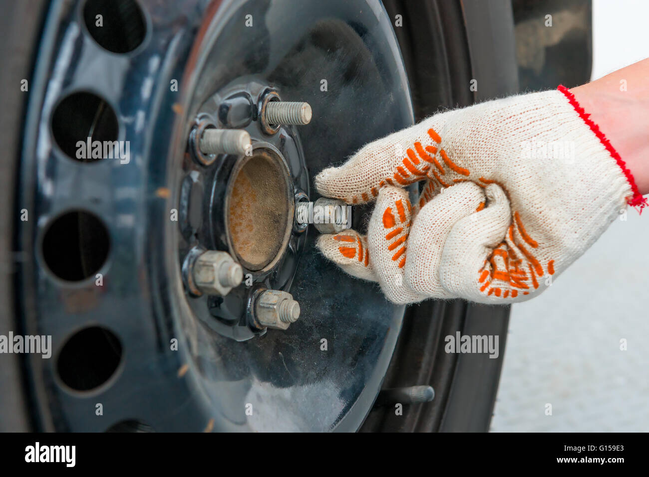 man's hand unscrews the nuts on the car wheel, close-up shot Stock ...