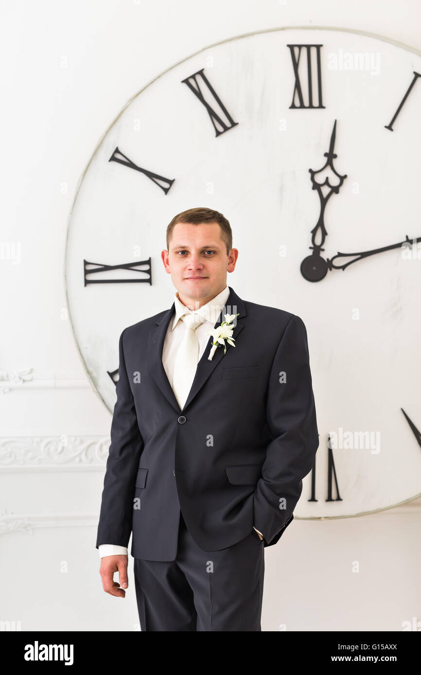 Man in black suit with big clock on background, time concept Stock ...