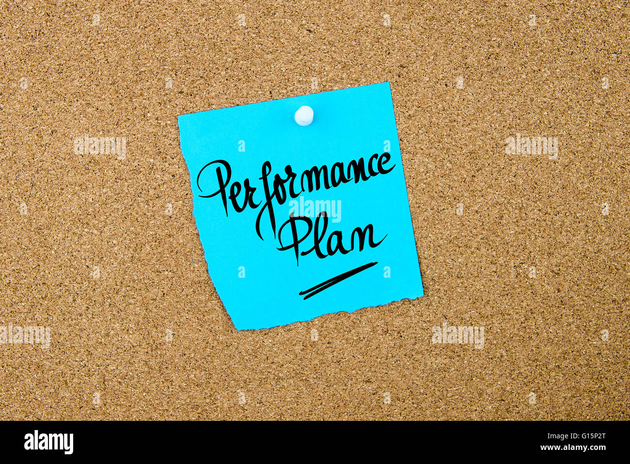 Performance Plan written on blue paper note pinned on cork board with ...