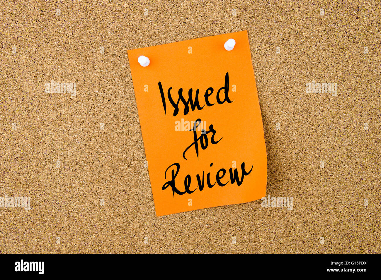 Issued For Review written on orange paper note pinned on cork board ...