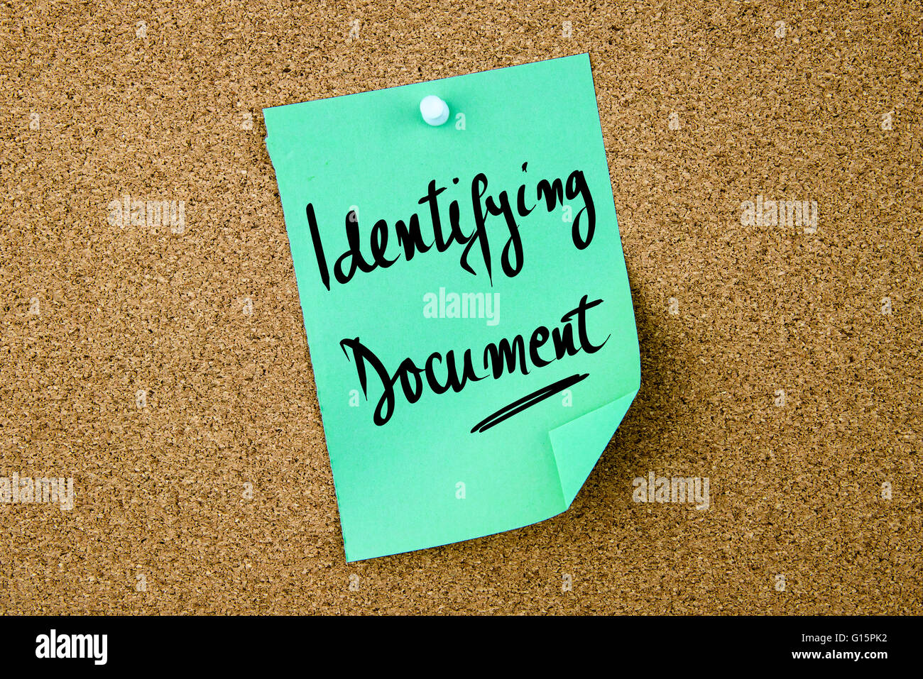 Identifying Document written on green paper note pinned on cork board ...