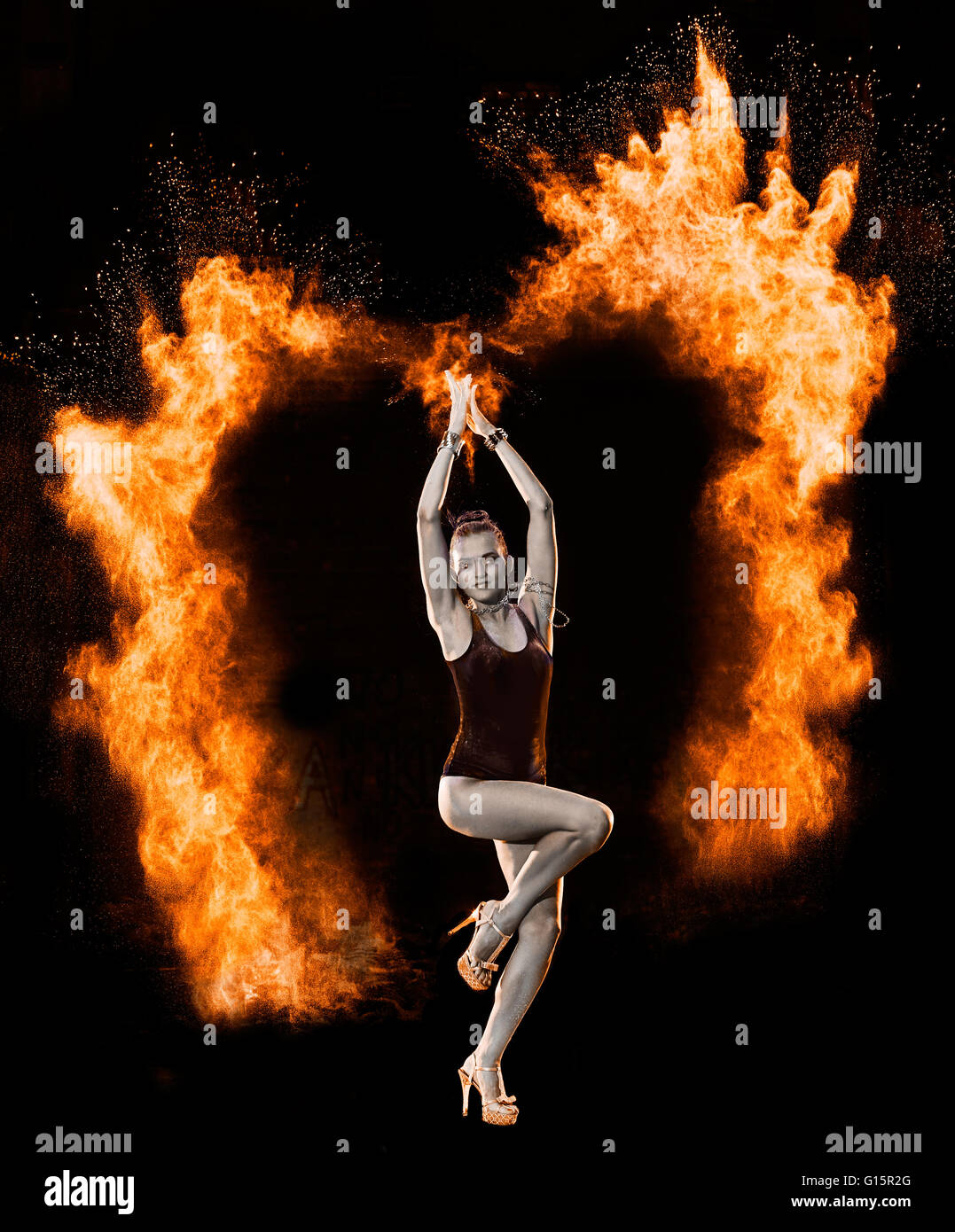 Young woman jumping in fire red powder cloud on black background Stock ...