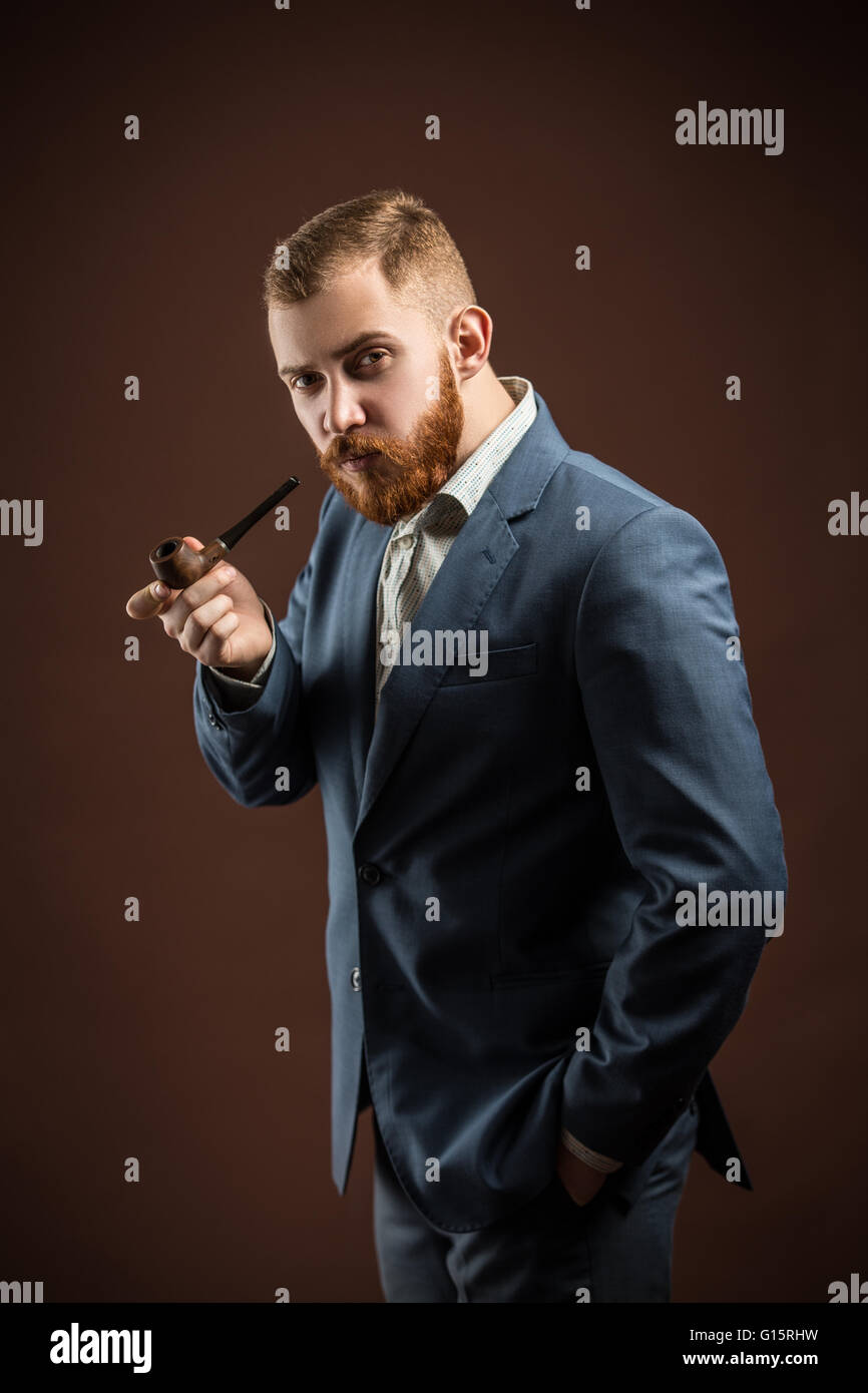 Elegant man with beard holding smoking pipe Stock Photo - Alamy