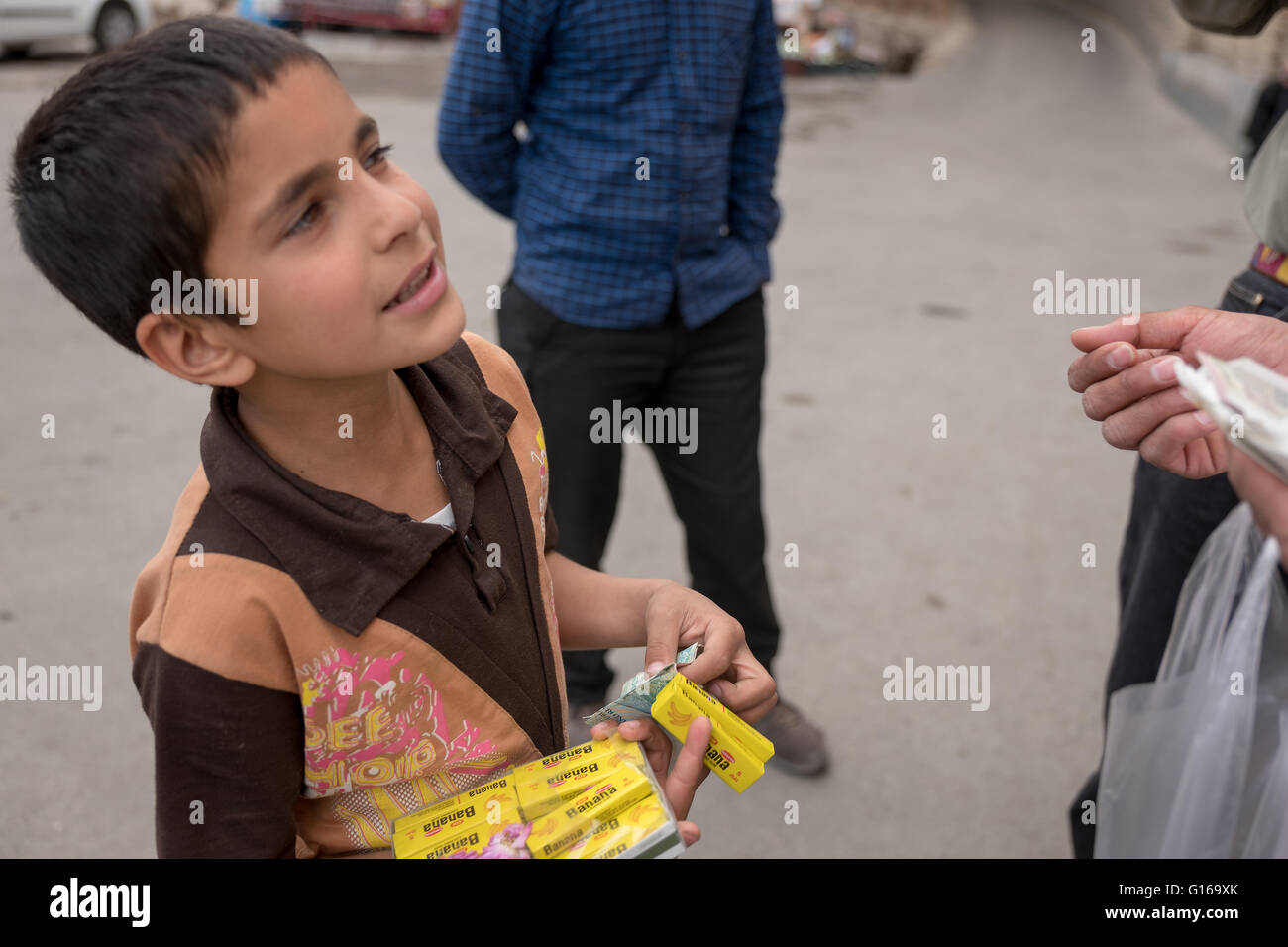 Young Iranian boy selling chewing gum outside the Fin Garden in Kashan ...