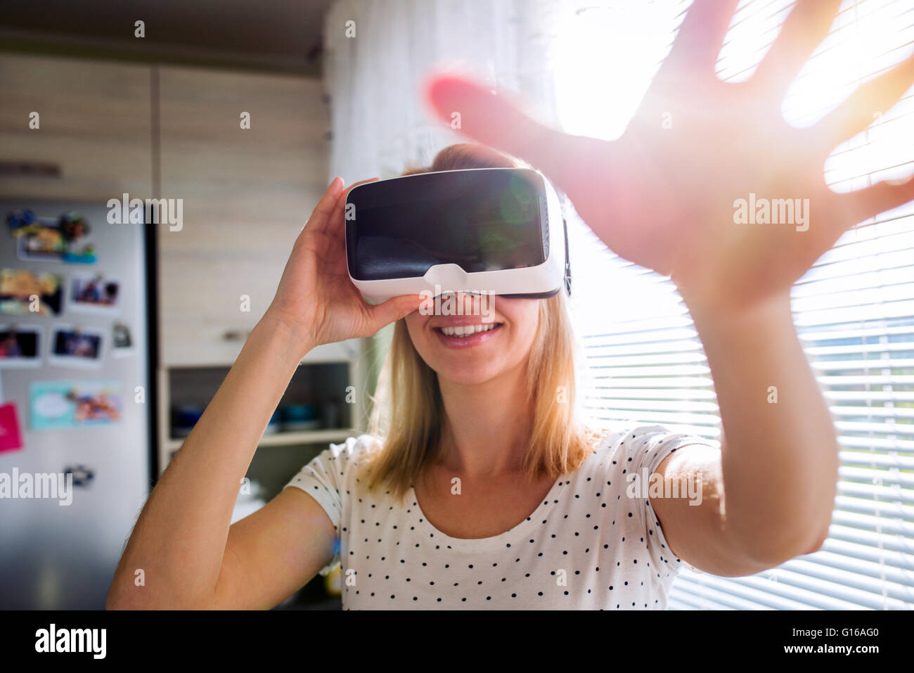 Woman wearing virtual reality goggles standing in a kitchen Stock Photo ...