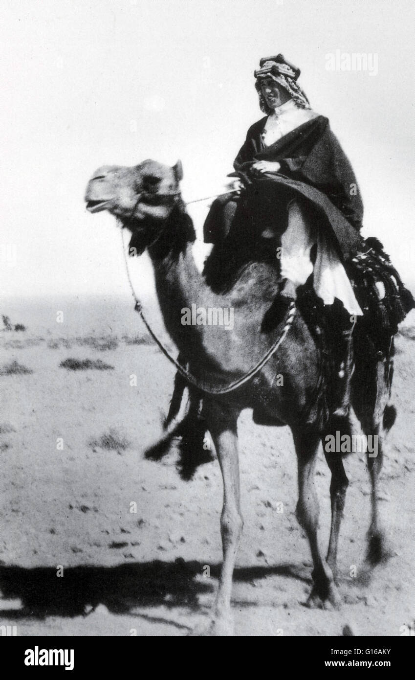 Undated photograph of T.E. Lawrence astride a camel in traditional Arab ...