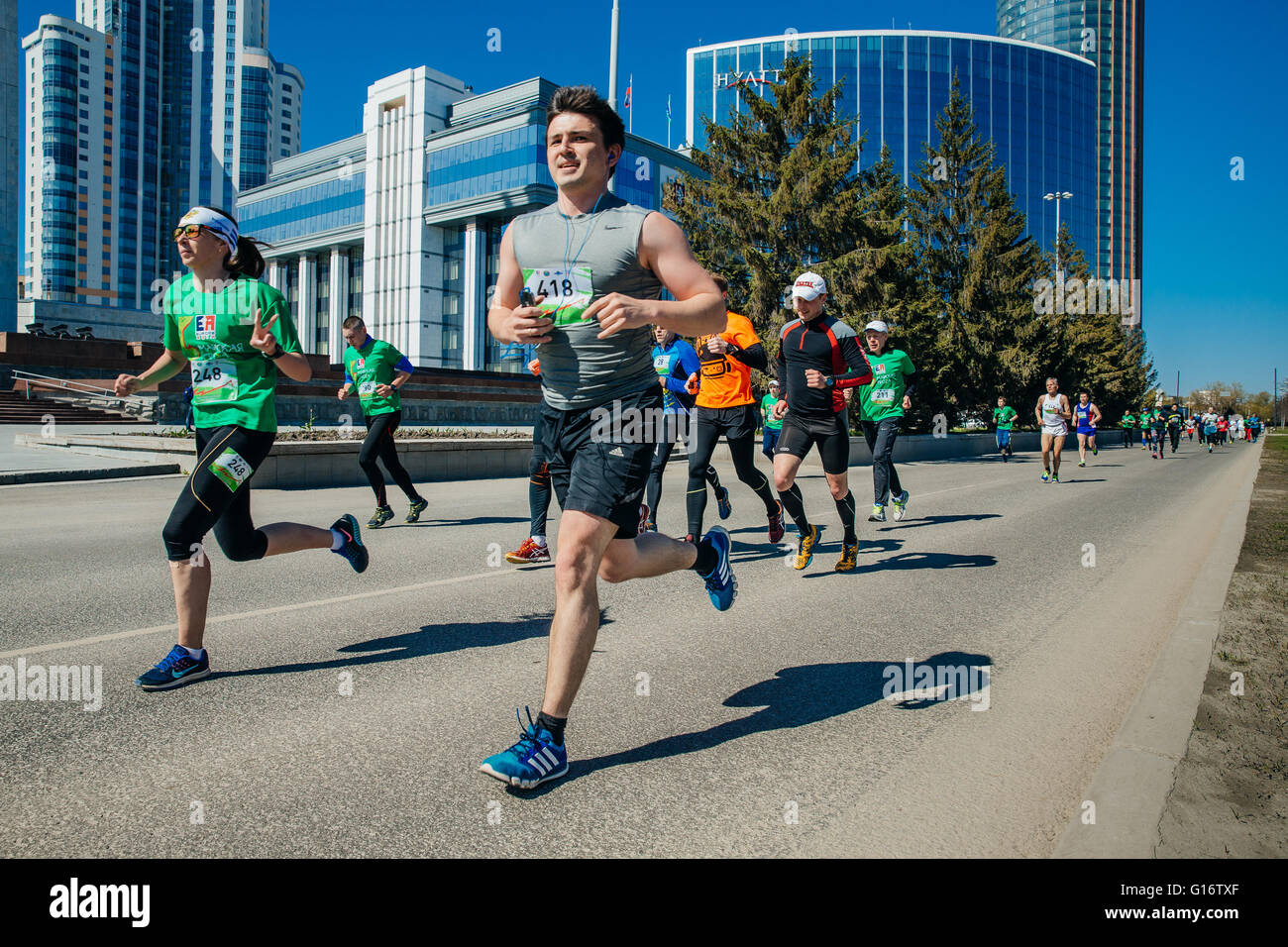 group of athletes runners running through streets of city with ...