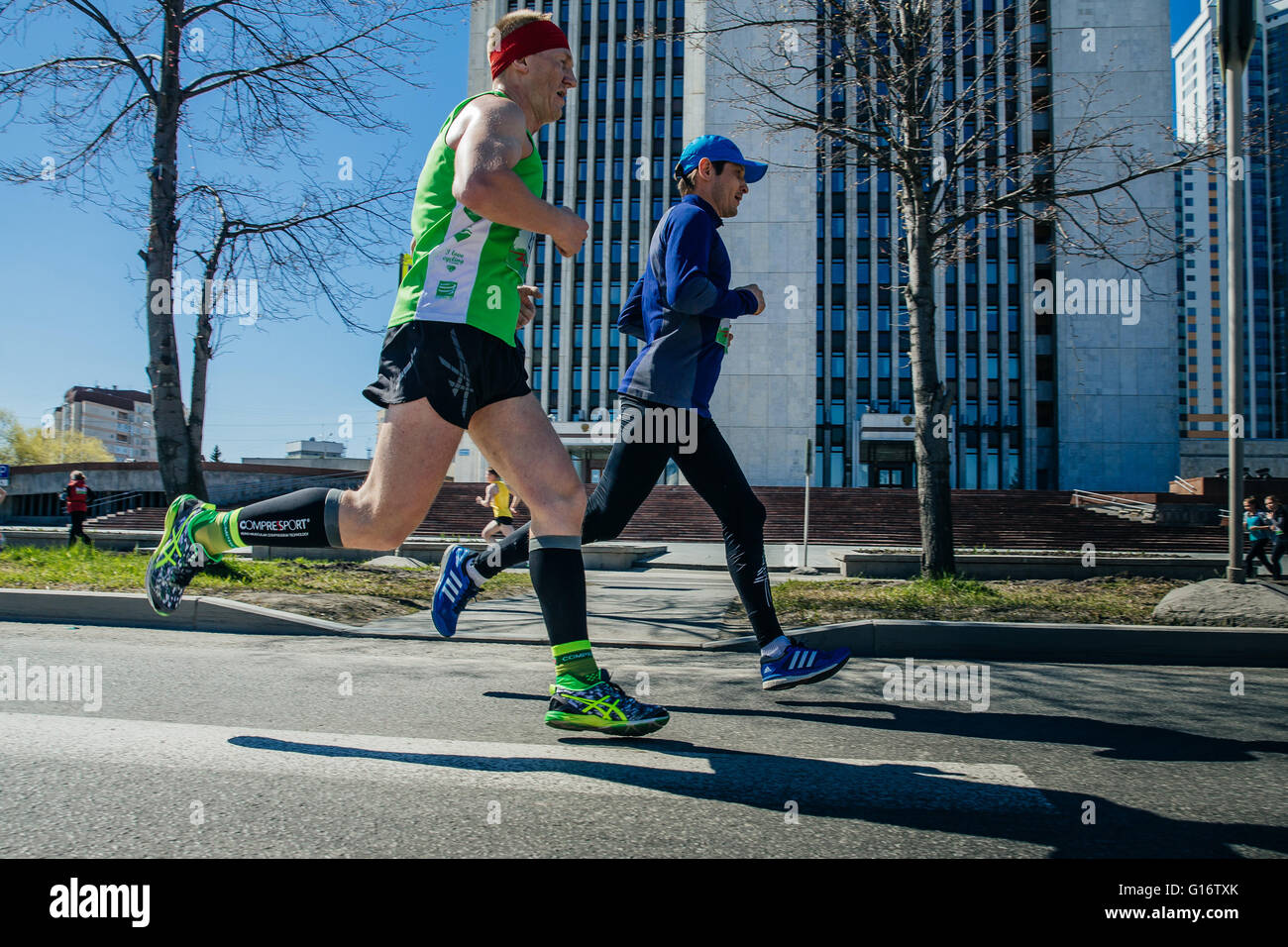 two young runners on streets of city on building background during City ...