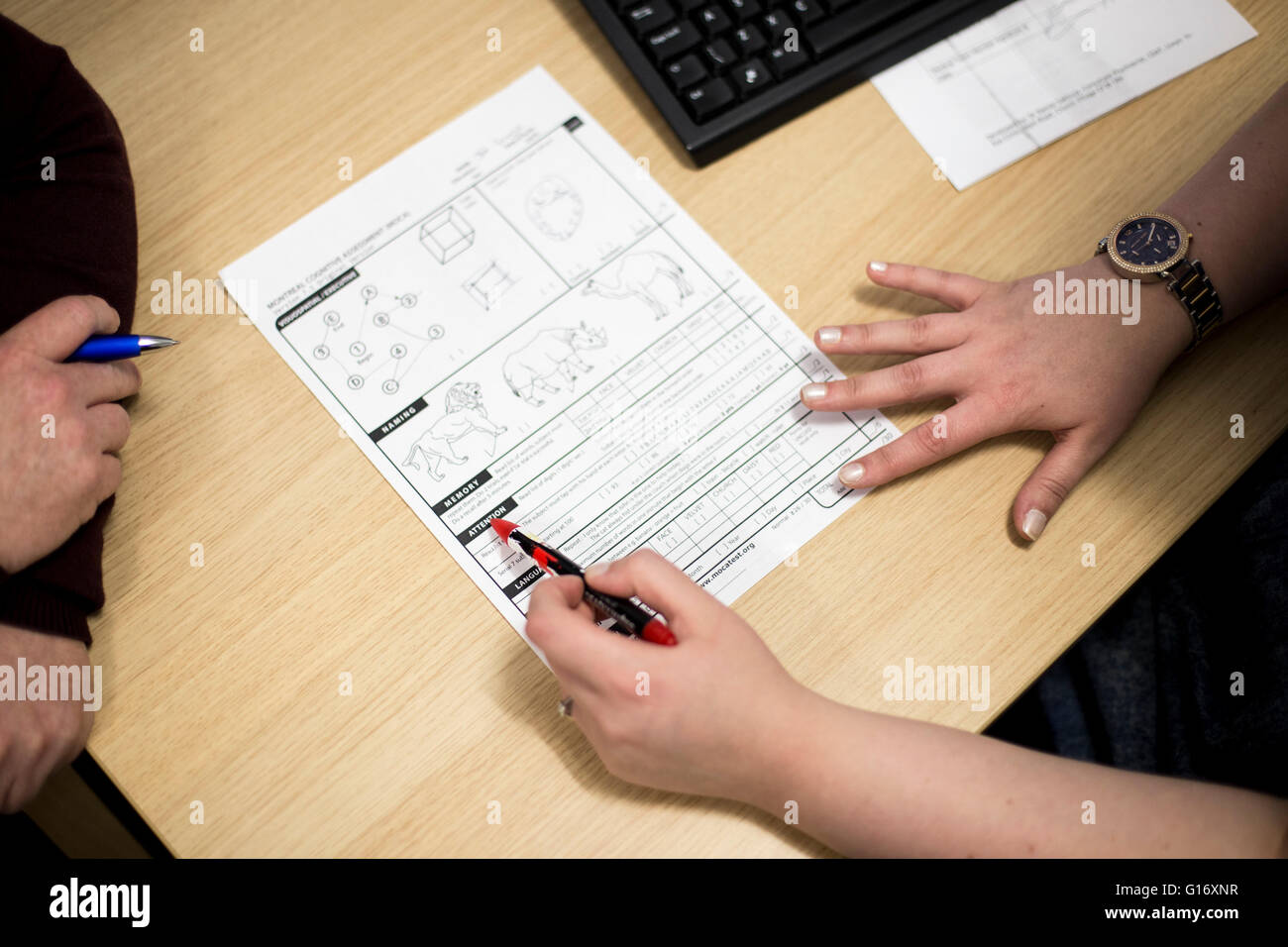 Image of people pondering over paperwork on a desk Stock Photo - Alamy