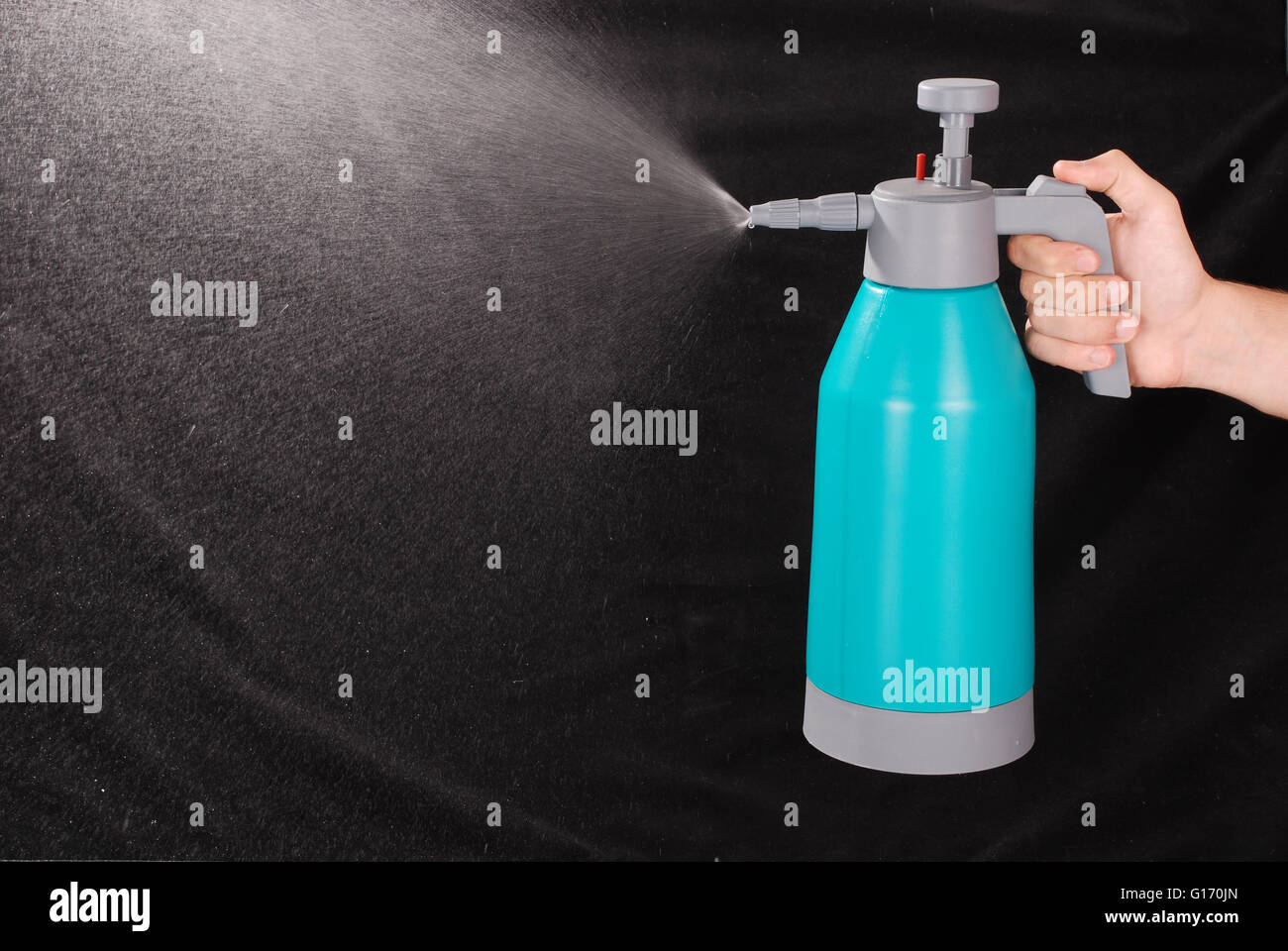 Male hand holding spray bottle isolated on black background Stock Photo ...