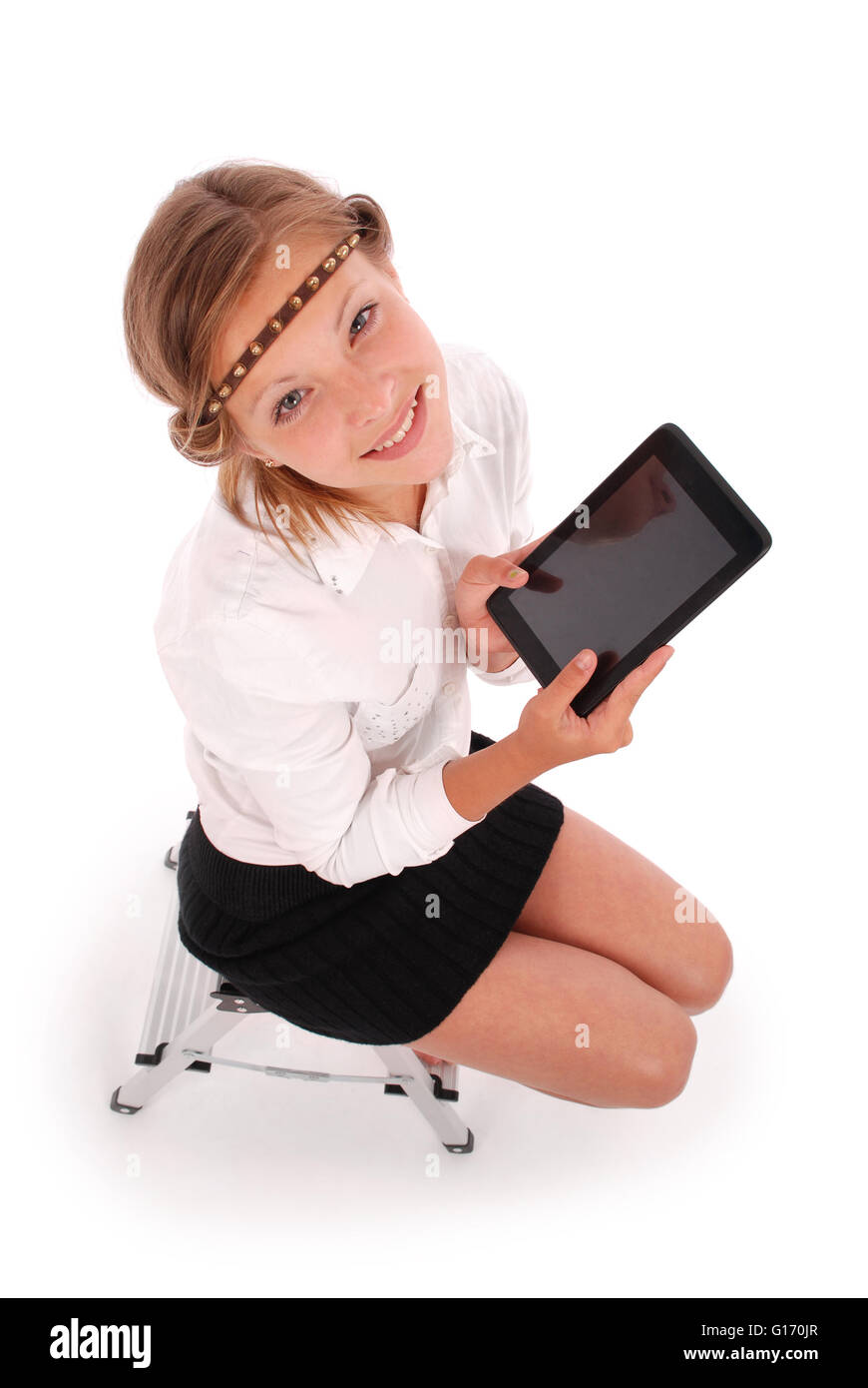 Girl showing tablet pc while sitting on the stairs isolated on white ...