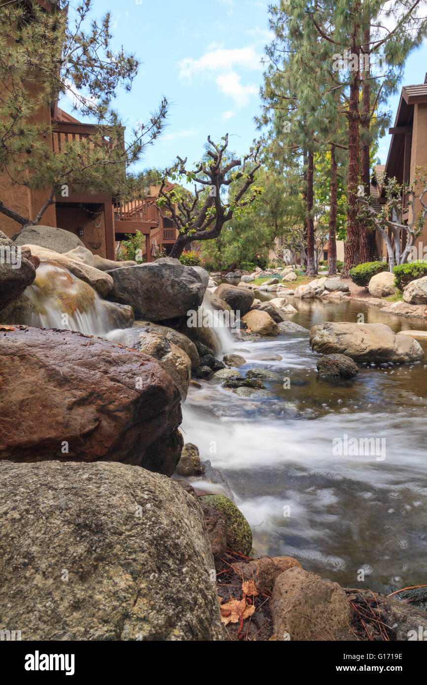 Orange, CA, USA —May 7, 2016: Plant life, koi fish and a waterfall in a ...