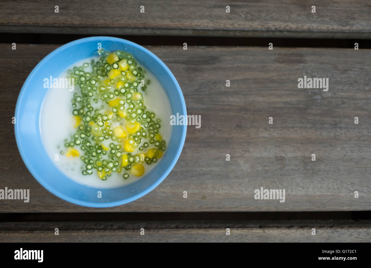 Tapioca pudding or Sakoo (Thai dessert) with coconut milk on wood table ...