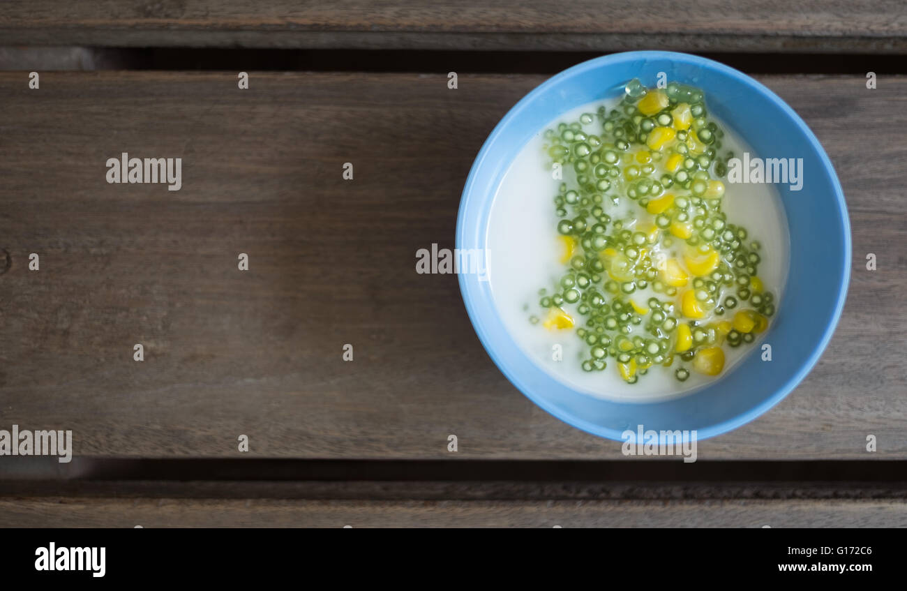 Tapioca pudding or Sakoo (Thai dessert) with coconut milk on wood table ...