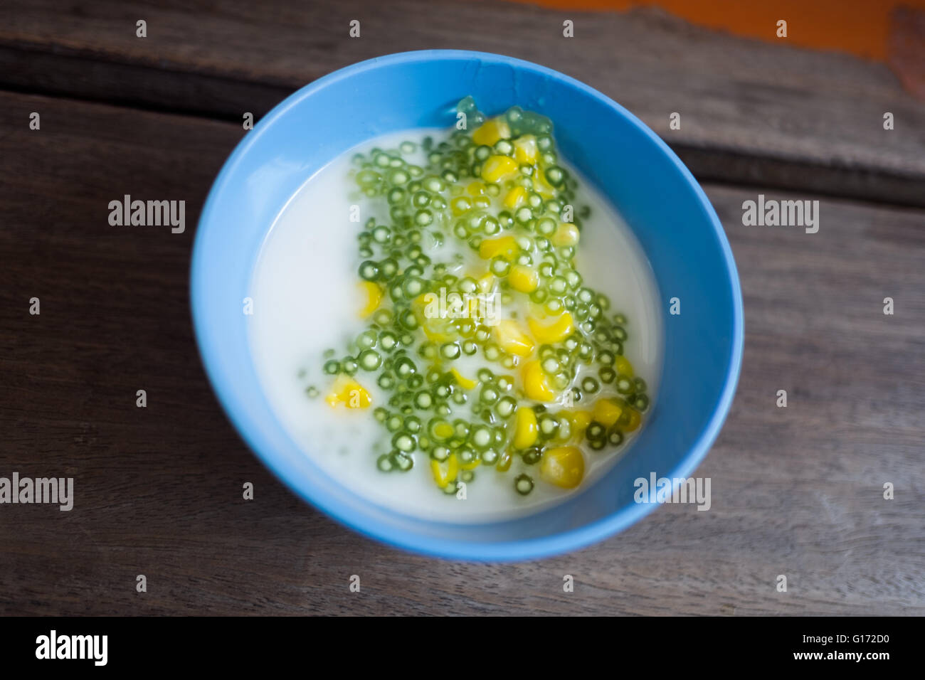 Tapioca pudding or Sakoo (Thai dessert) with coconut milk on wood table ...