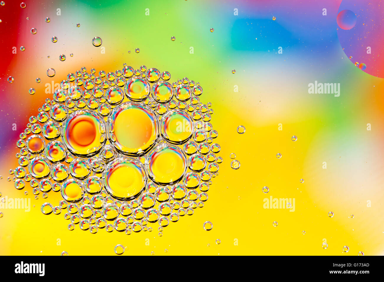 Oil drops in water on a coloured background Stock Photo - Alamy