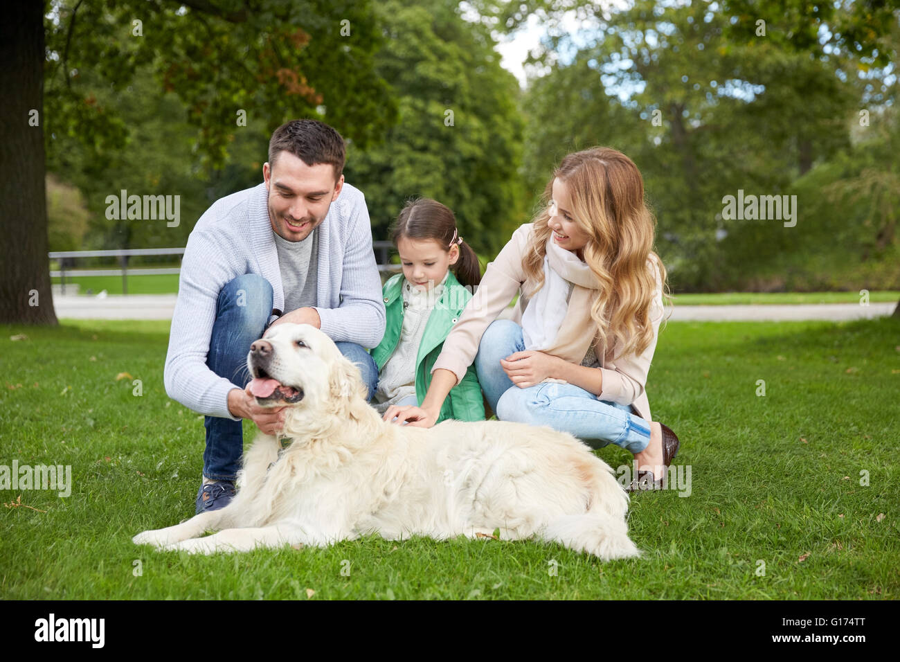 happy family with labrador retriever dog in park Stock Photo - Alamy