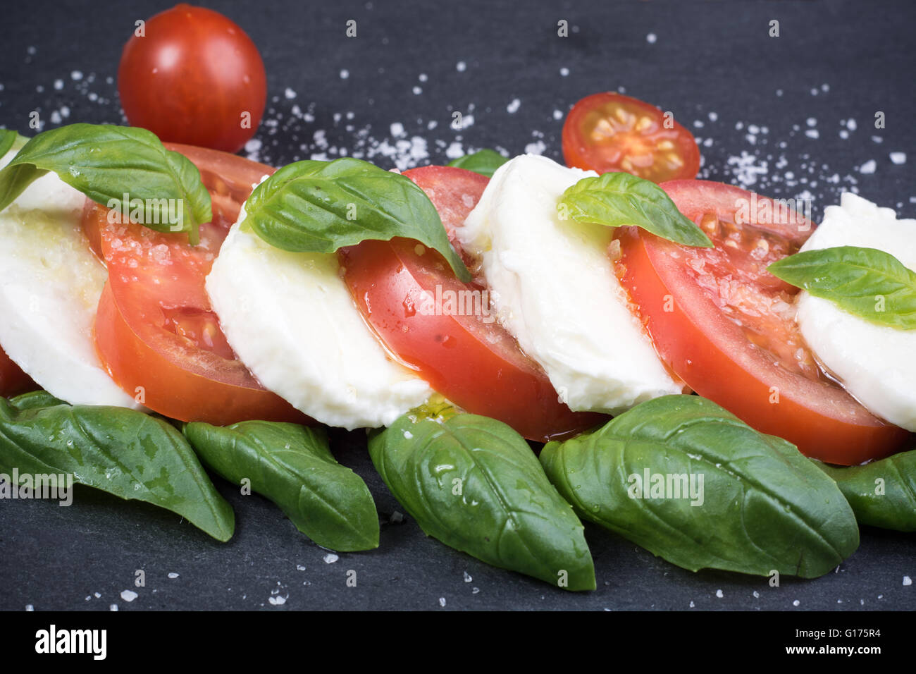 Fresh Italian caprese salad with mozzarella, tomatoes and green basil ...