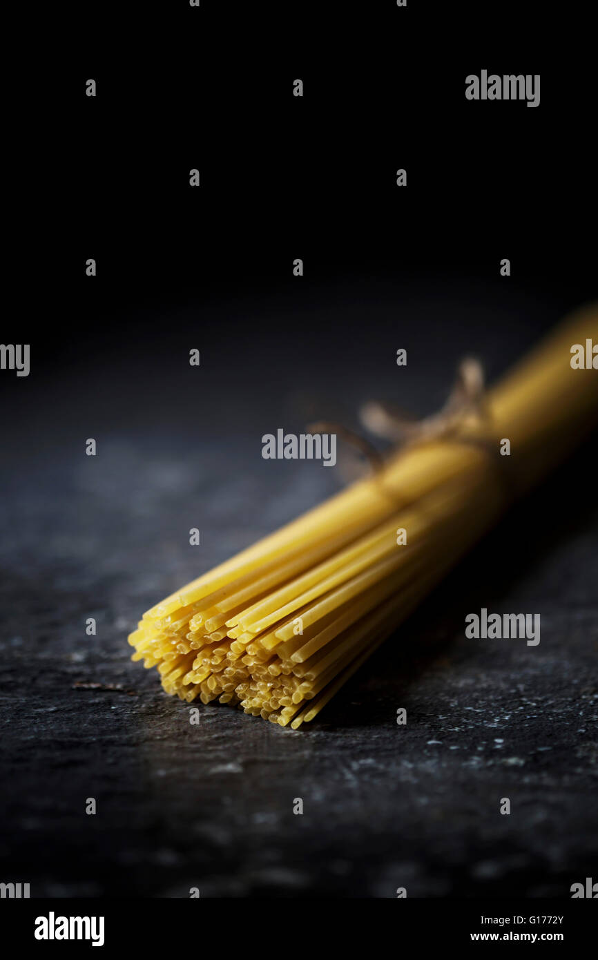 Close-up of raw spaghetti on dark background Stock Photo - Alamy