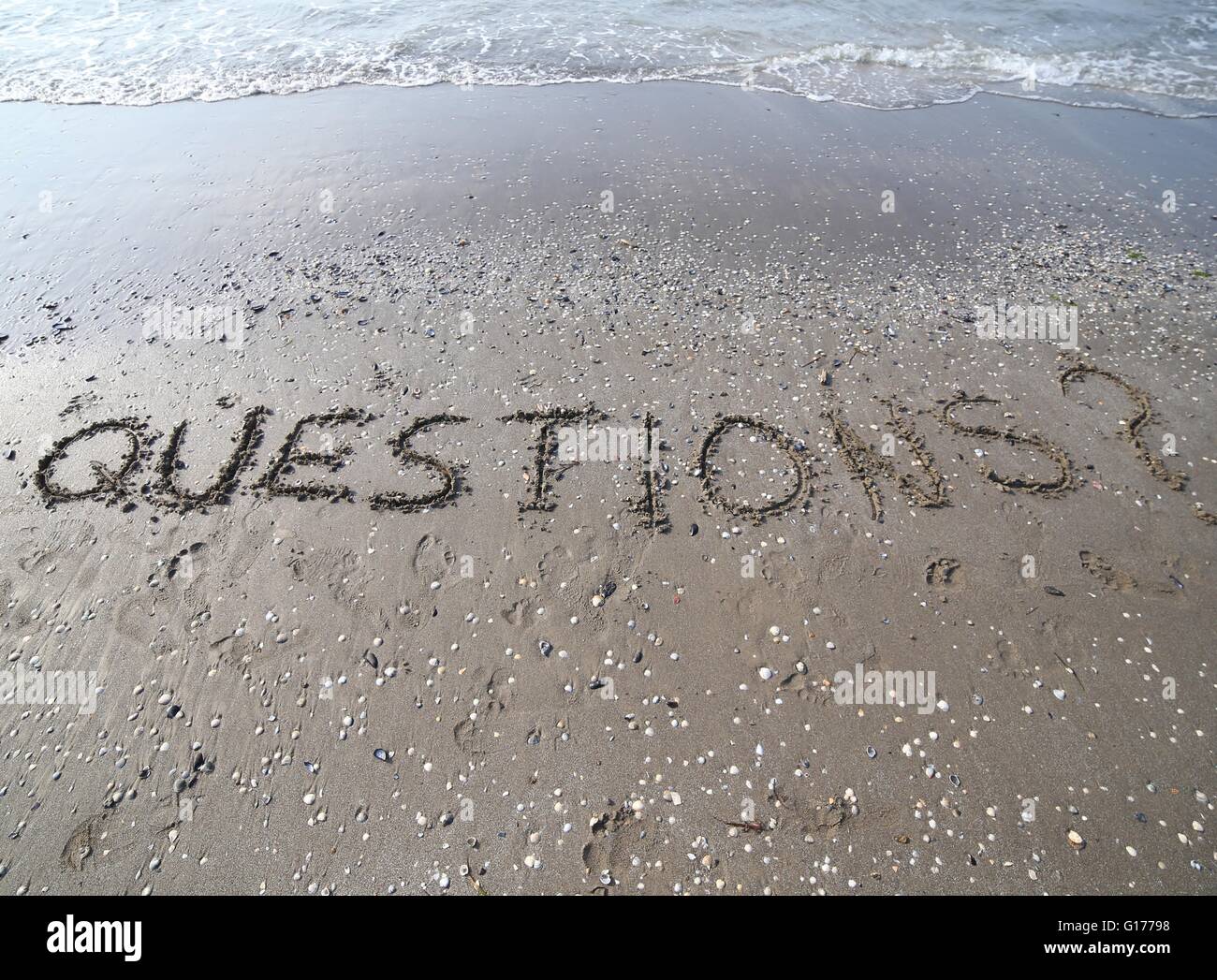 QUESTIONS written in the sand of the beach Stock Photo - Alamy