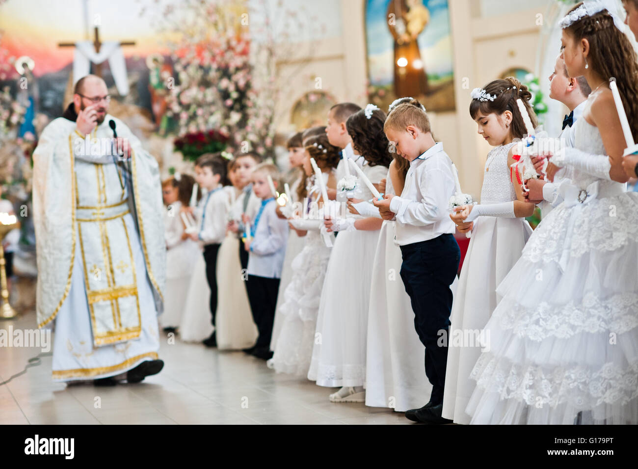LVIV, UKRAINE - MAY 8, 2016: Priest at ceremony of a First Communion ...