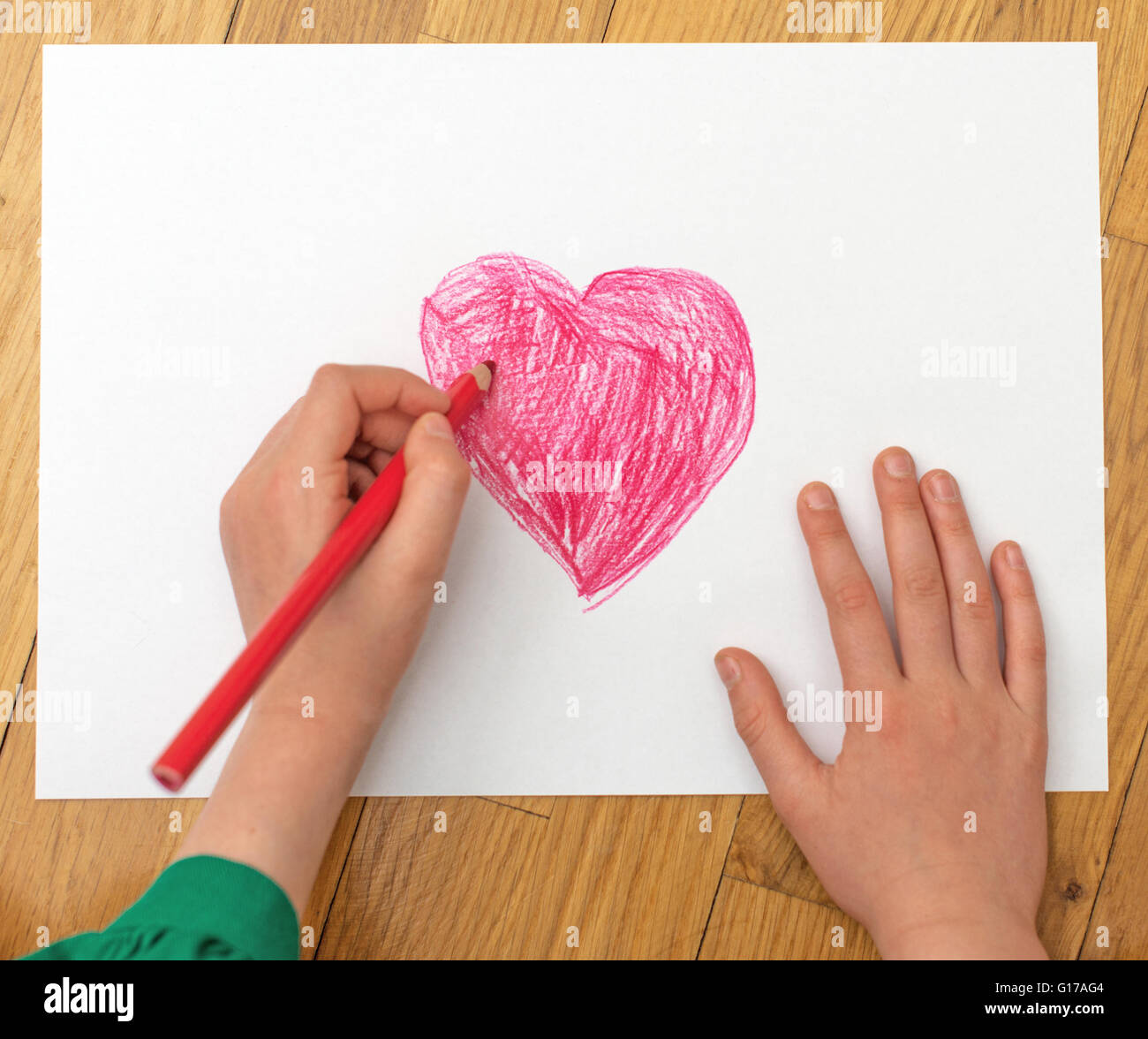 Child's hand drawing red heart on paper Stock Photo - Alamy
