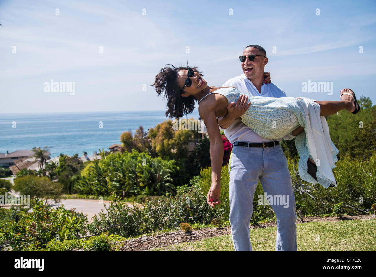 Man carrying woman on hill near ocean, Los Angeles, California Stock ...