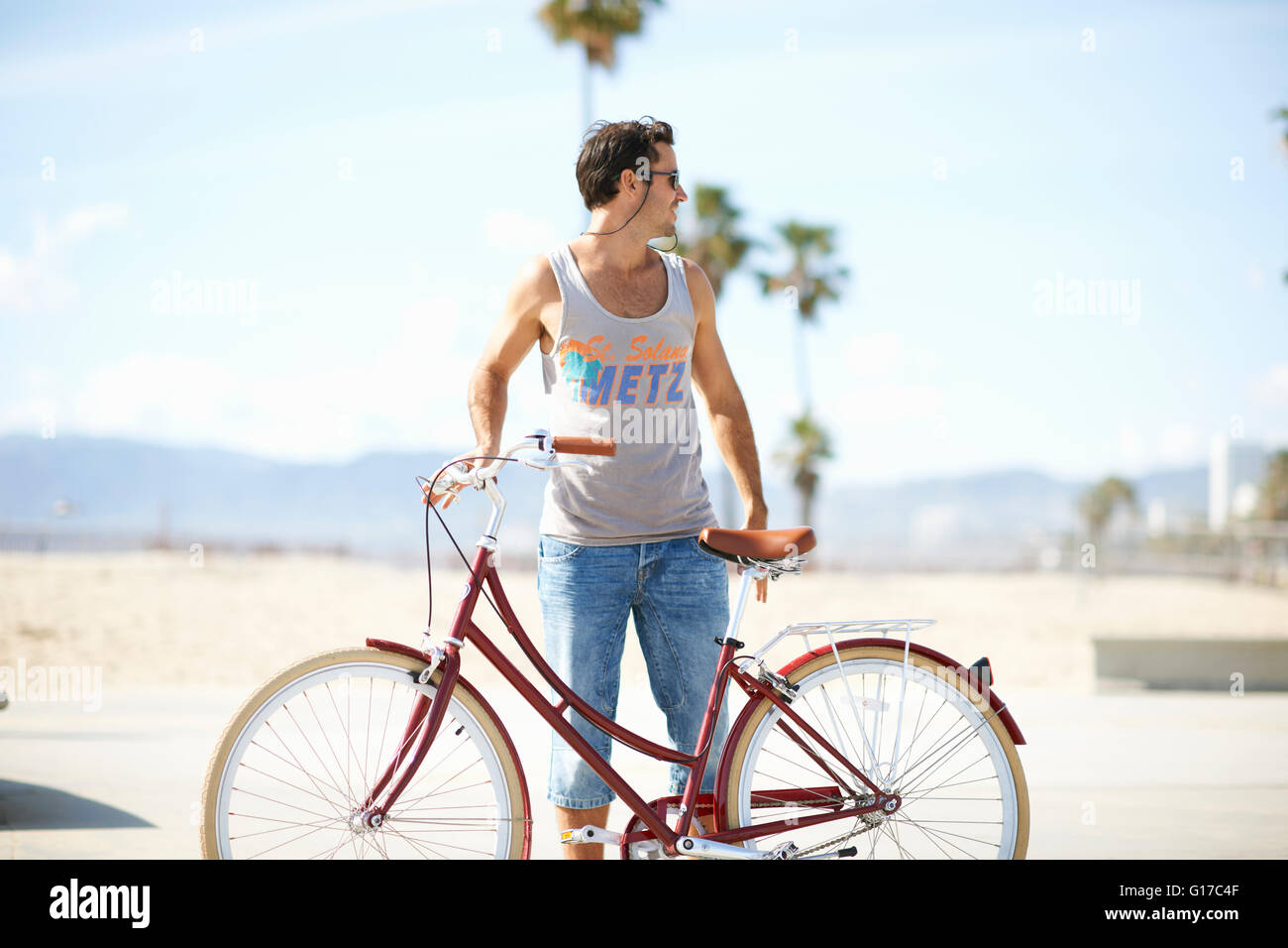 Man looking back whilst cycling at Venice Beach, Los Angeles ...