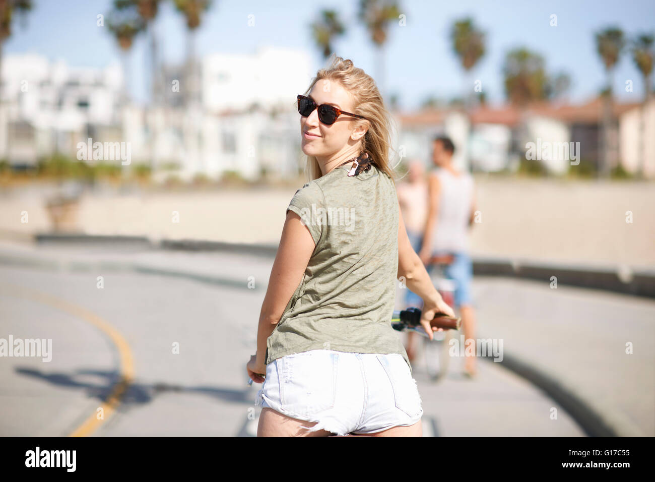 Young female cyclist looking over her shoulder whilst cycling at Venice ...