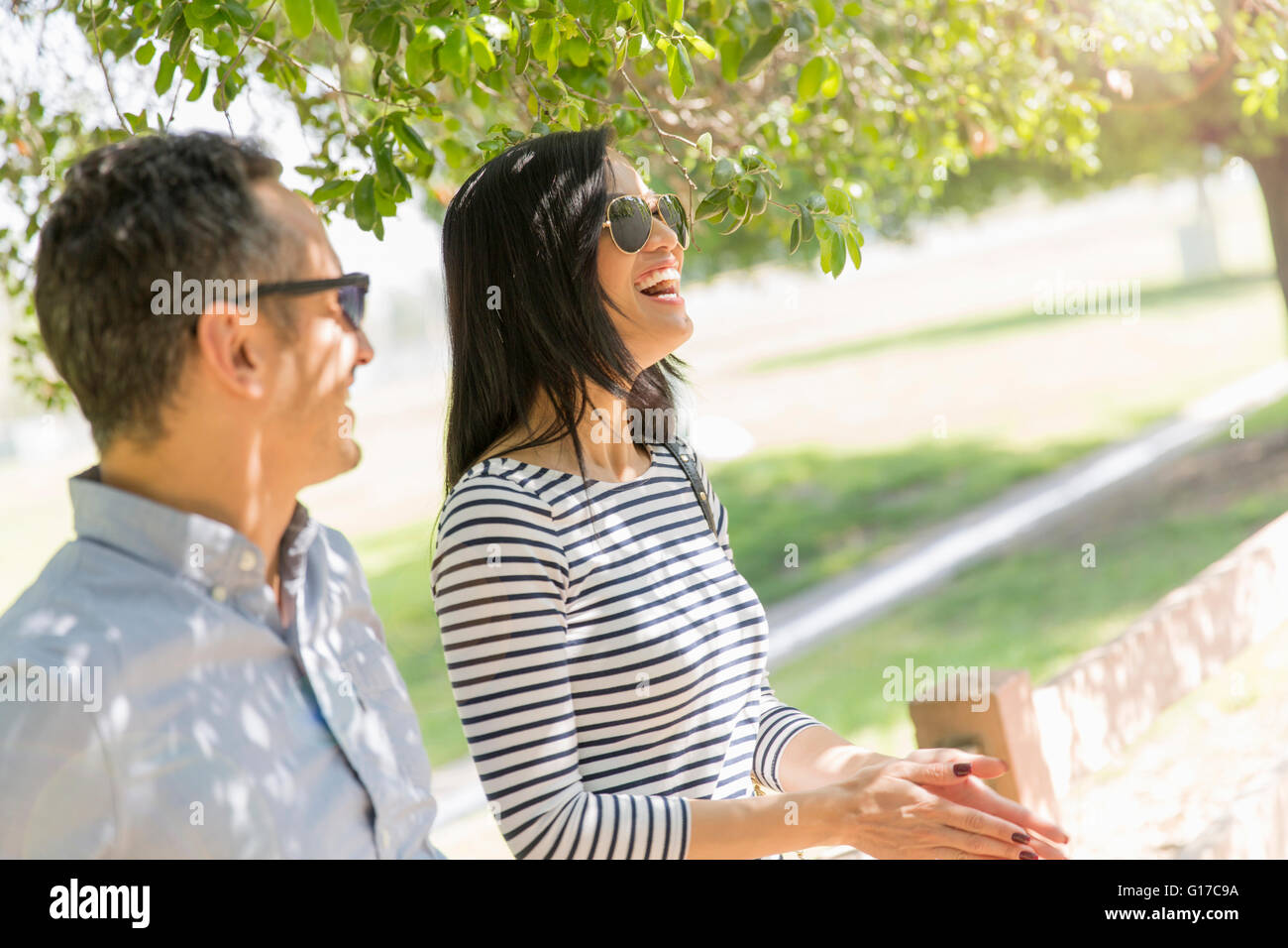 Couple underneath tree laughing Stock Photo - Alamy