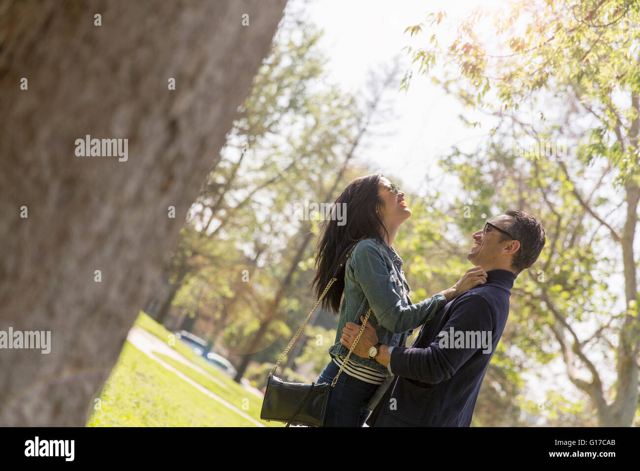 Couple in park face to face hugging and smiling Stock Photo - Alamy