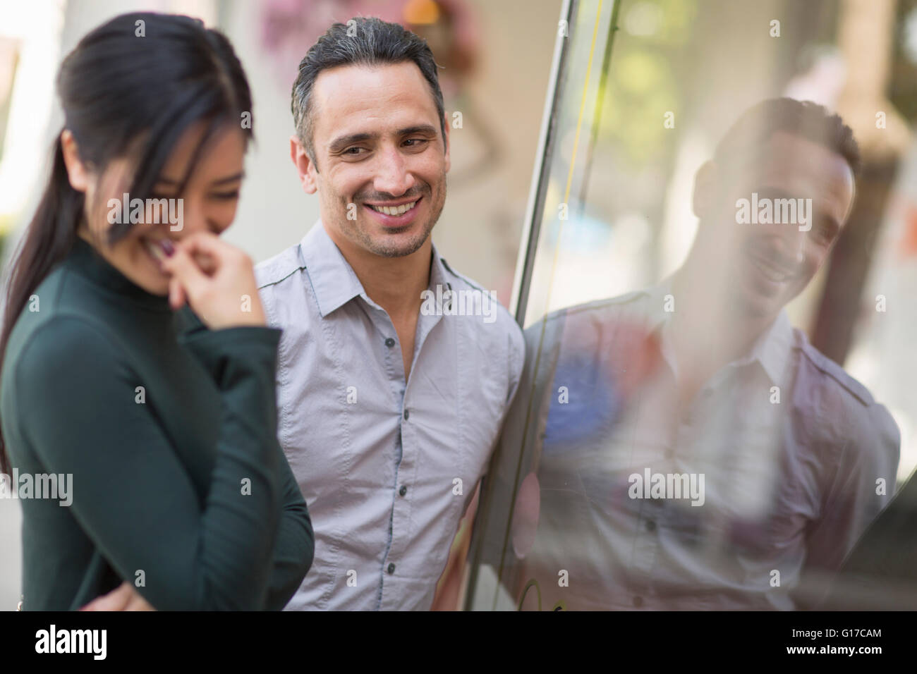 Couple window shopping laughing Stock Photo - Alamy