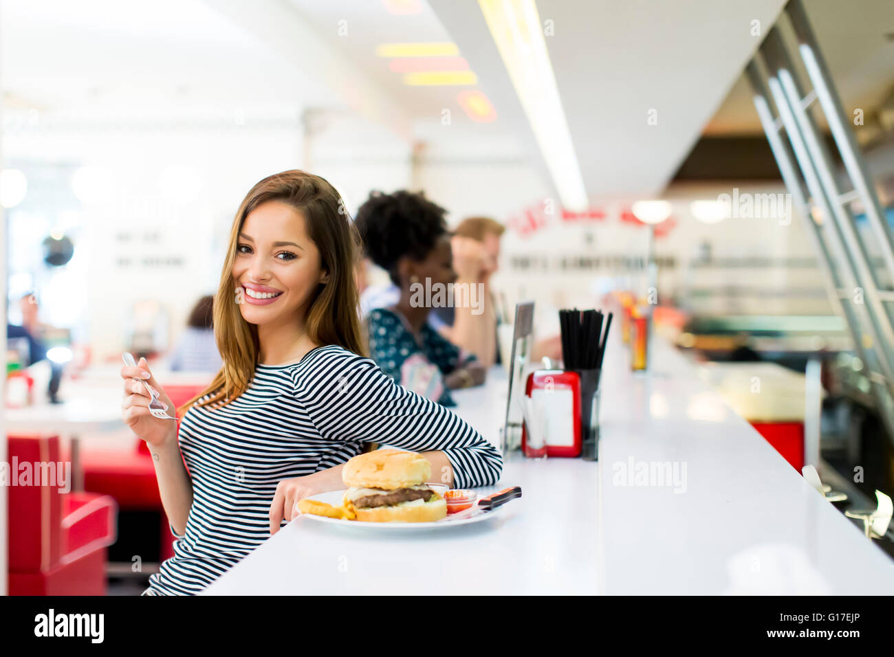 View of the young woman eating in the diner Stock Photo - Alamy