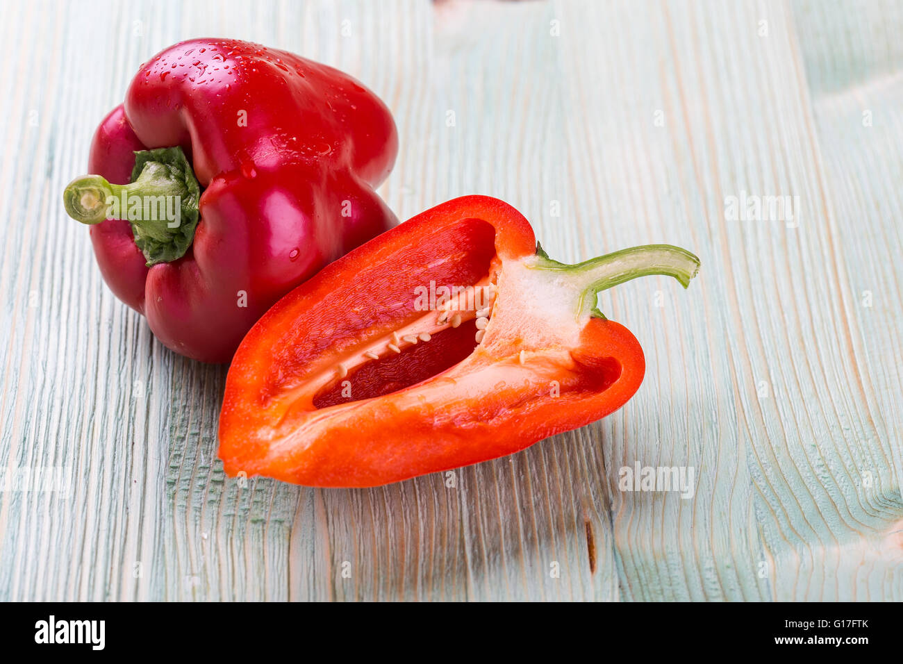 Fresh red bell peppers on a bright wooden background Stock Photo - Alamy
