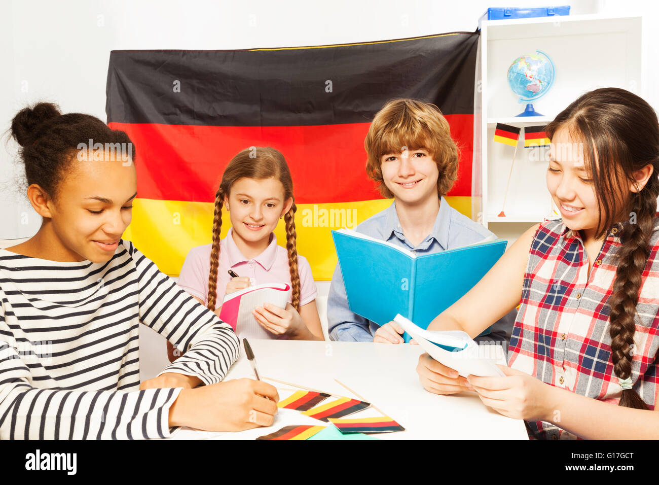 Four multiethnic students studying German at class Stock Photo - Alamy