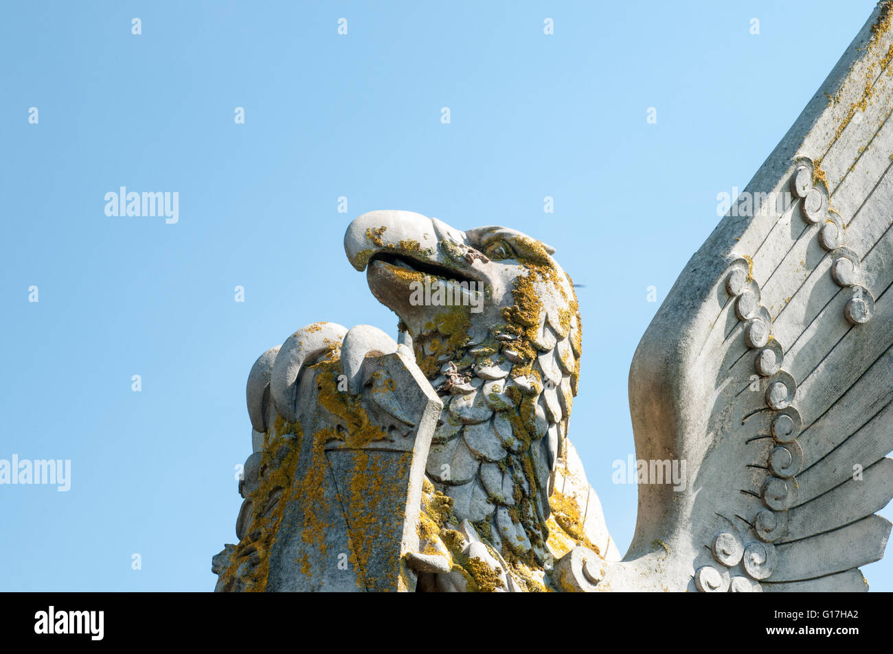 Statue of a winged mythical creature on a plinth holding a shield Stock ...
