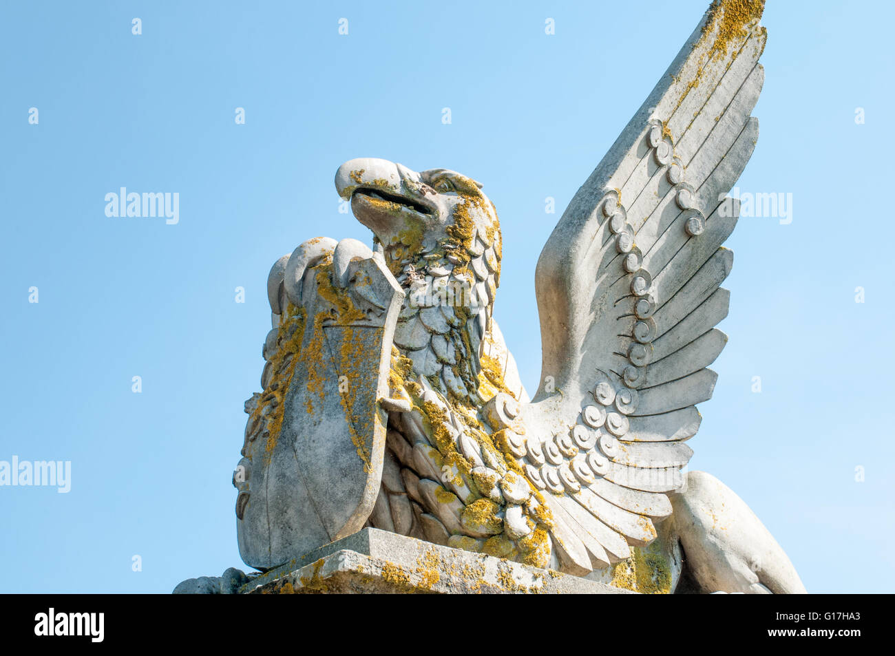Statue of a winged mythical creature on a plinth holding a shield Stock ...